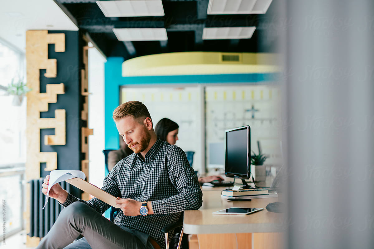 "Businessman Reading A File At The Office" by Stocksy Contributor ...