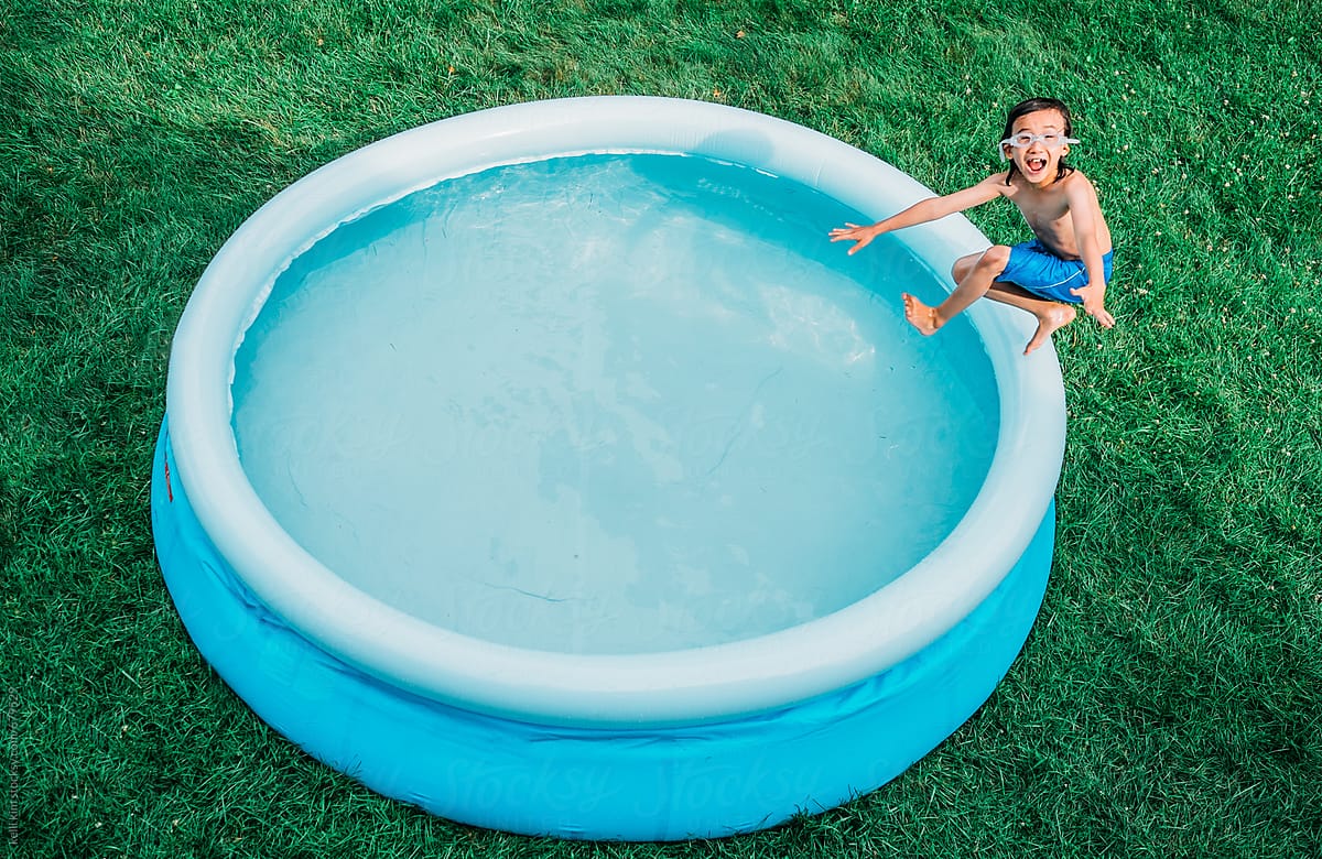 "Young Boy Leaps Into Inflatable Pool" by Stocksy Contributor "Kelli ...
