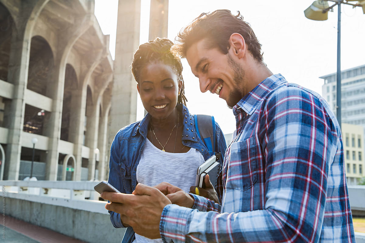 "Students Laugh Together Looking At Phone" by Stocksy Contributor "Jovo ...