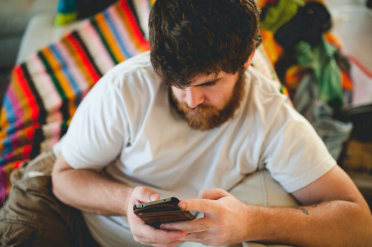 "Man Checking Phone" by Stocksy Contributor "Courtney Rust" - Stocksy
