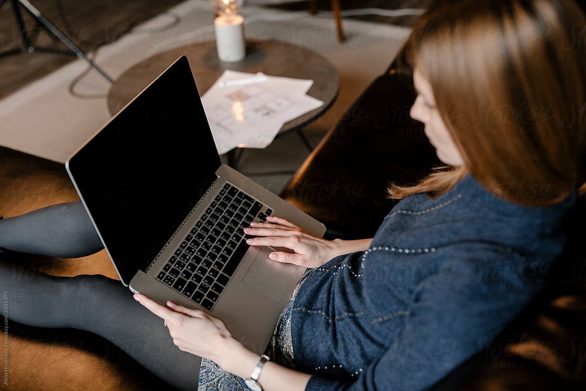 "Stylish Woman Sitting With Laptop On Knees And Using." by Stocksy ...