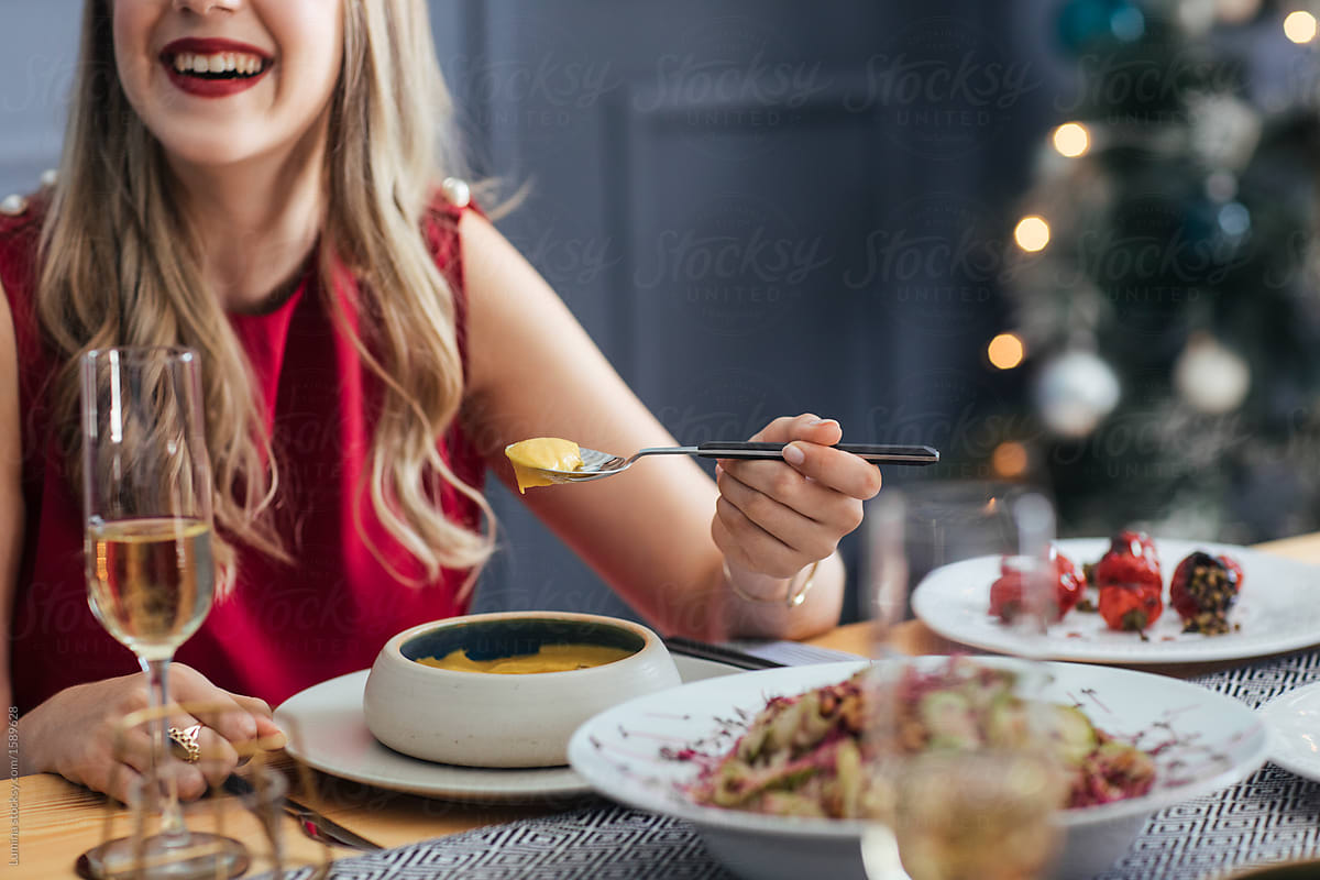 "Woman Eating At Christmas Dinner" by Stocksy Contributor "Lumina ...