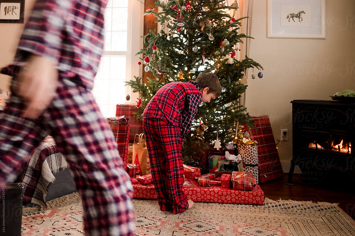 "Little Boy Getting A Present From Under The Christmas Tree" by Stocksy ...