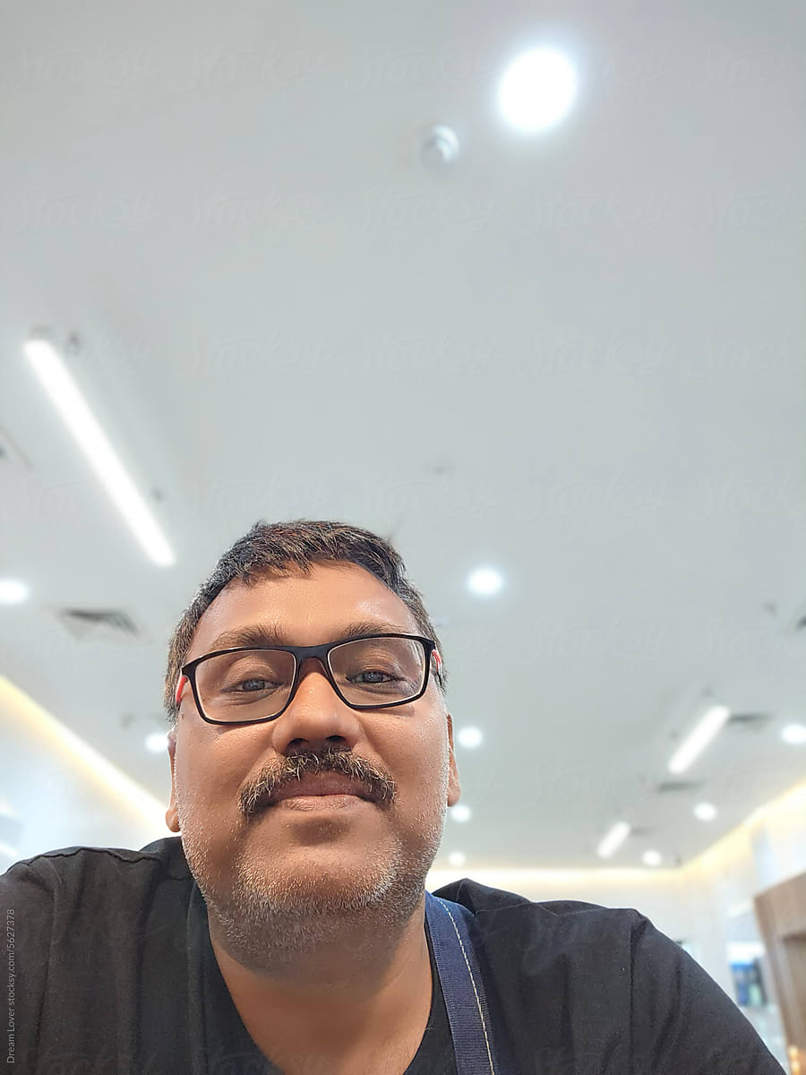 Middle Aged Indian Man Taking Selfie With Smartphone By Stocksy Middle Aged Indian Man Taking Selfie With Smartphone By Stocksy
