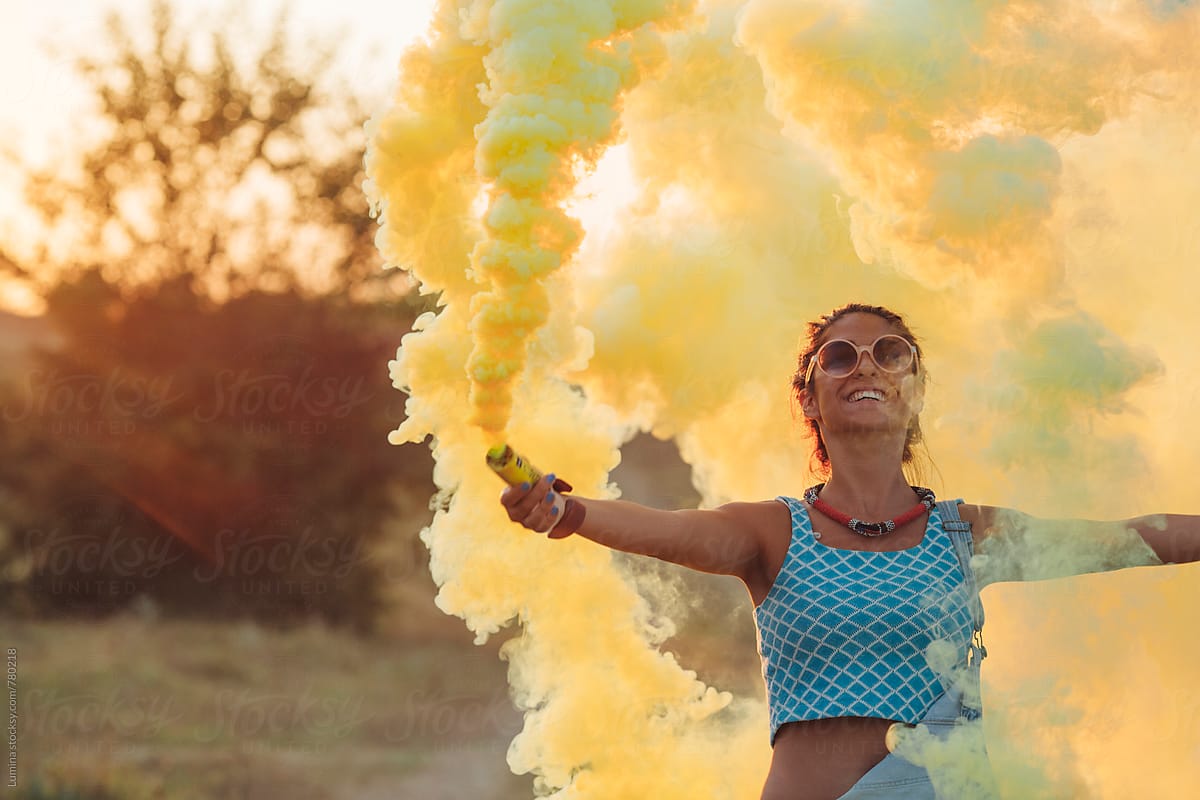 "Woman Holding A Smoke Bomb" by Stocksy Contributor "Lumina" - Stocksy