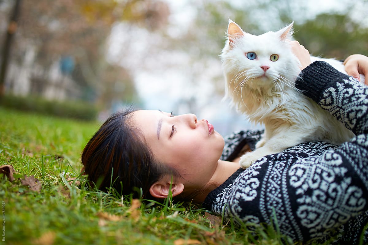 "Young Woman With Her Cat Outdoor" by Stocksy Contributor "Bo Bo" - Stocksy
