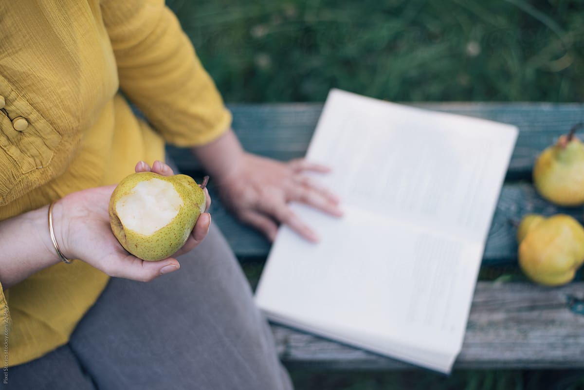 "Woman Eating Pear And Reading" by Stocksy Contributor "Sibila and ...