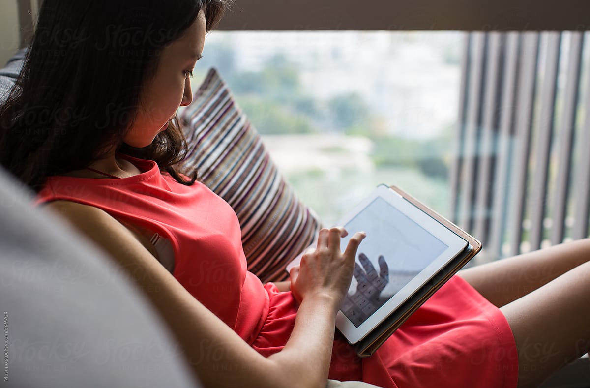 "Woman Browsing Tablet Computer" by Stocksy Contributor "Mosuno" - Stocksy
