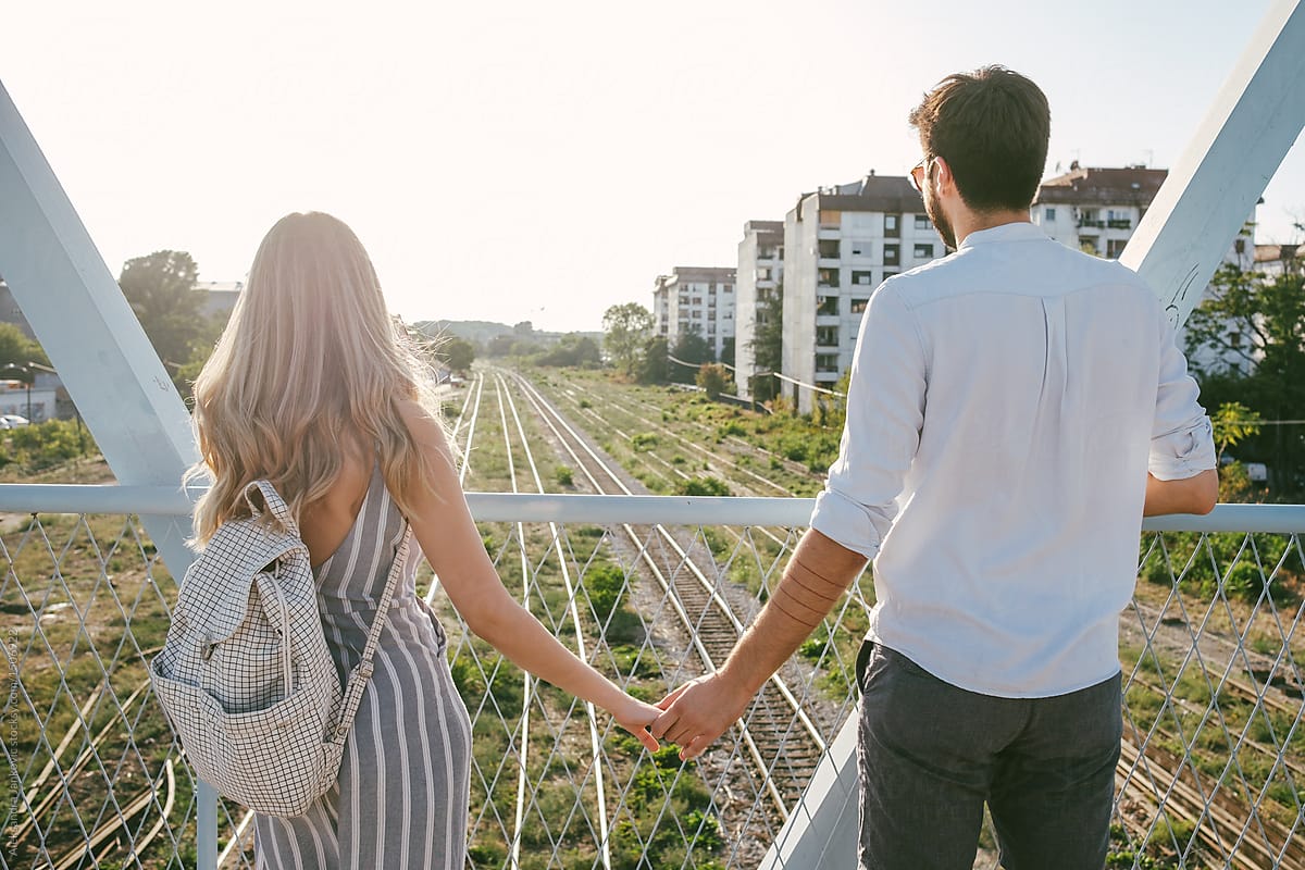 "Young Couple Looking Down From A Bridge At The Railroad" by Stocksy ...