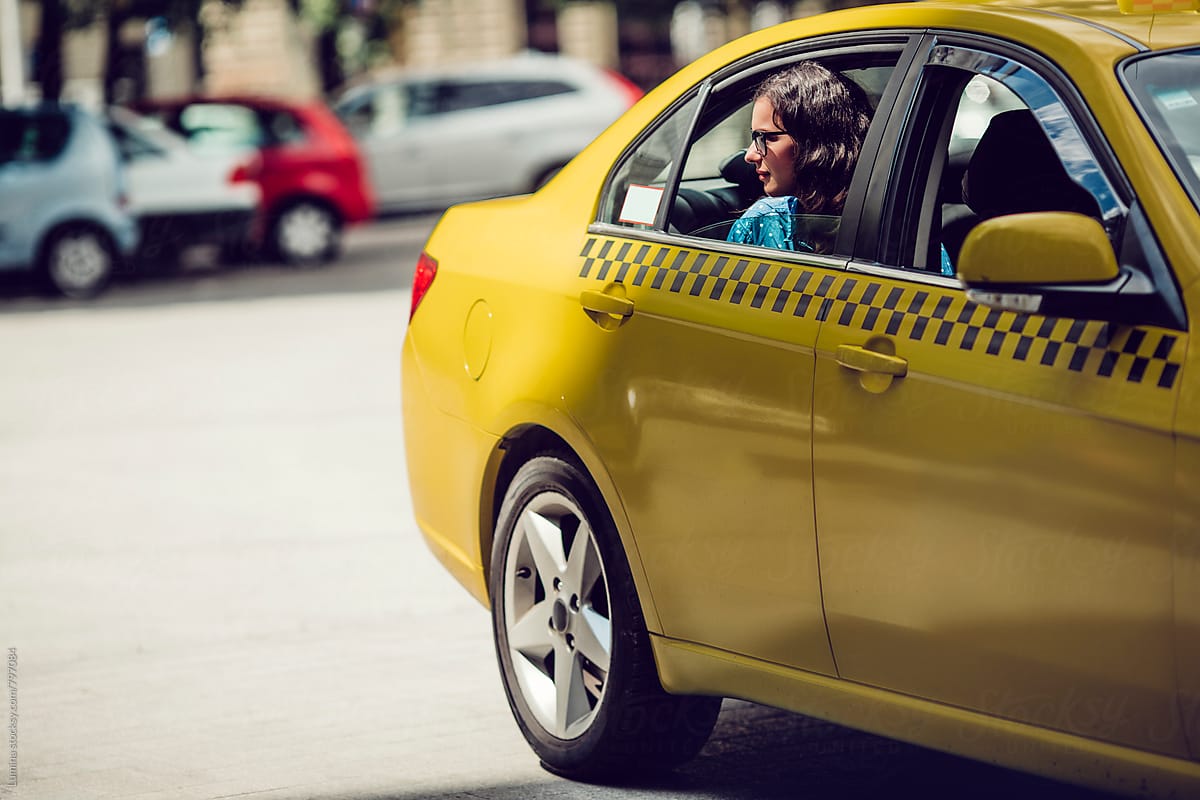 "Woman Sitting In A Yellow Taxi" by Stocksy Contributor "Lumina" - Stocksy
