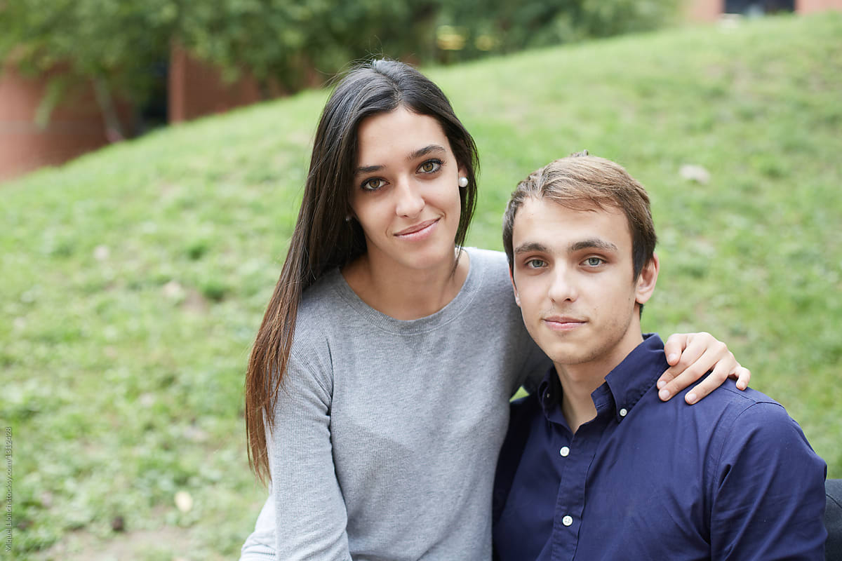 Hugging couple at public park looking at camera - Stock Image - Everypixel