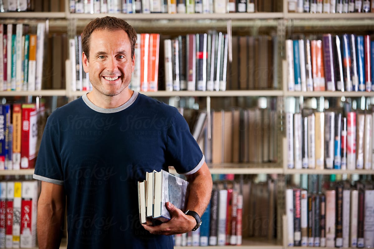 "Library: Happy Man With Stack Of Books" by Stocksy Contributor "Sean ...
