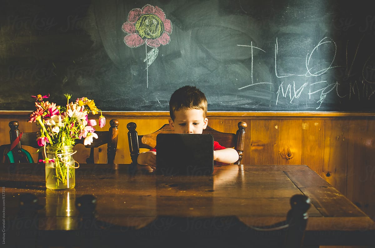 "Child Playing On Electronic Device At A Table" by Stocksy Contributor ...
