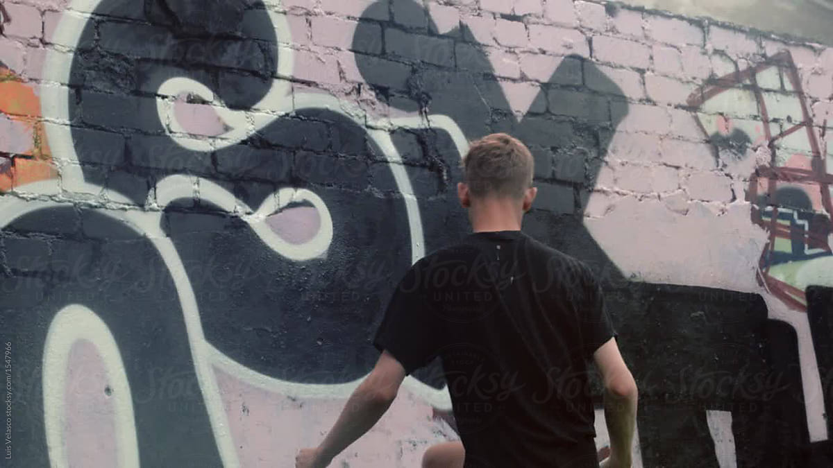 "Young Boy Street Artist Making A New Graffiti With A Spray On A Wall ...