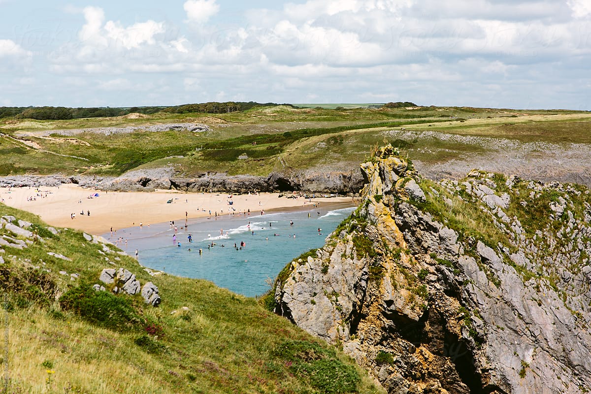 "A Busy UK Beach In Summer Glimpsed Through Rocks." by Stocksy ...