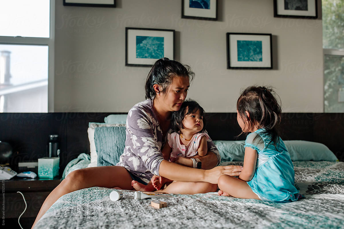 Deaf mother caring for young sick daughters - Stock Image - Everypixel