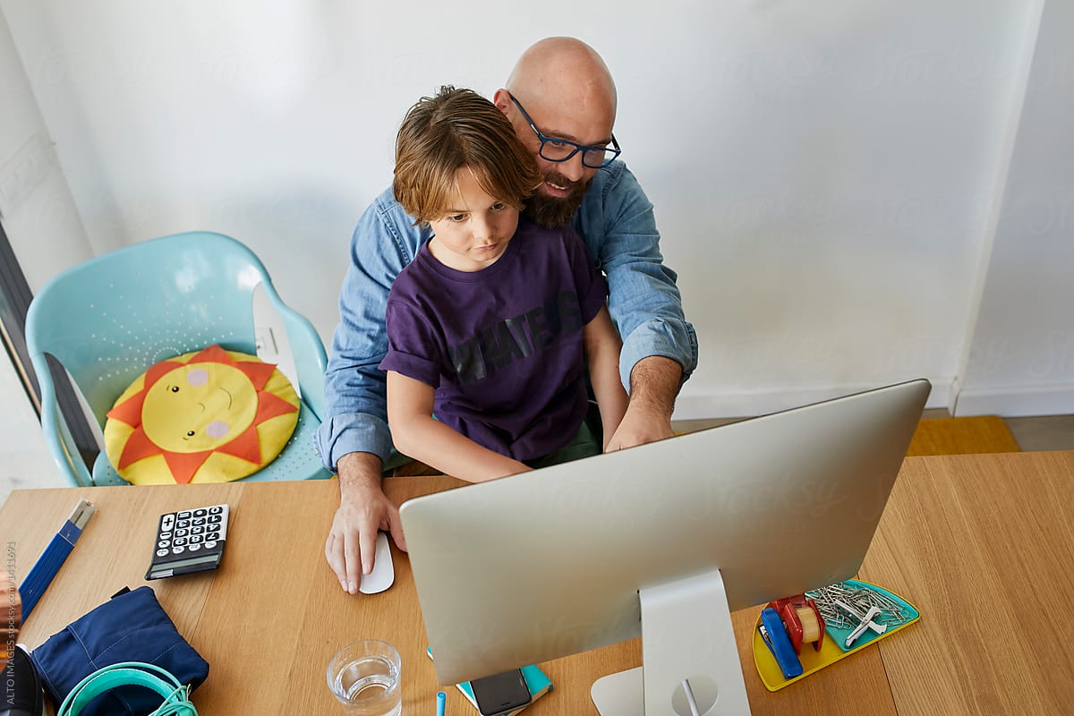 "Man Helping Son In Using Computer At Home" by Stocksy Contributor ...