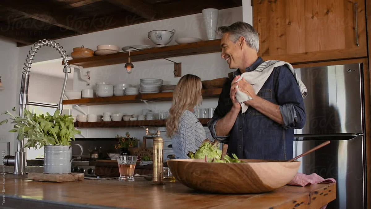 "Couple Cooking Together In The Kitchen Of A Rustic Modern Farmhouse ...