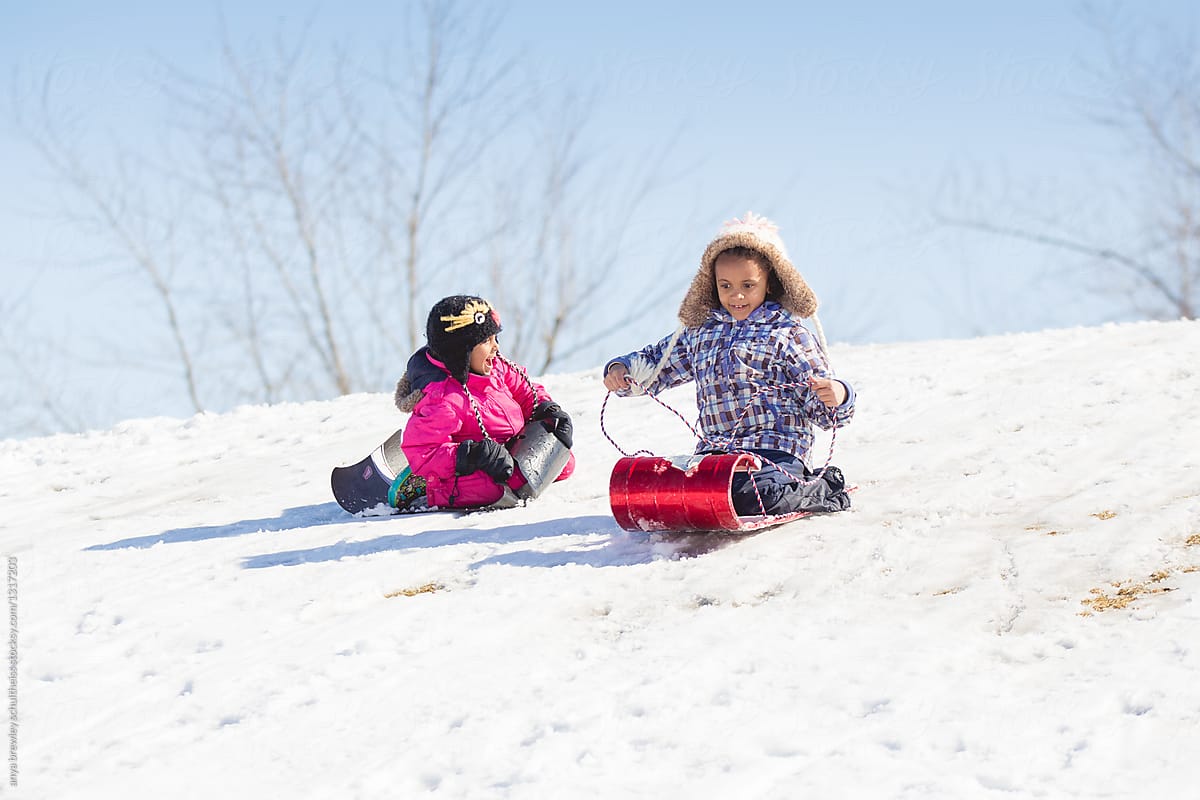 "Two Children Happily Tobogganing Down A Snowy Hill" by Stocksy ...