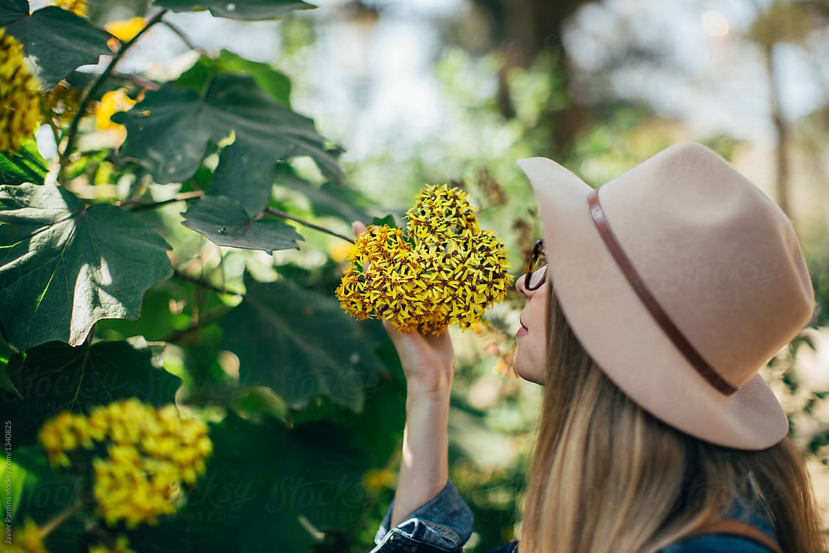 "Woman Sniffing Flowers In The Park" by Stocksy Contributor "Pardina ...