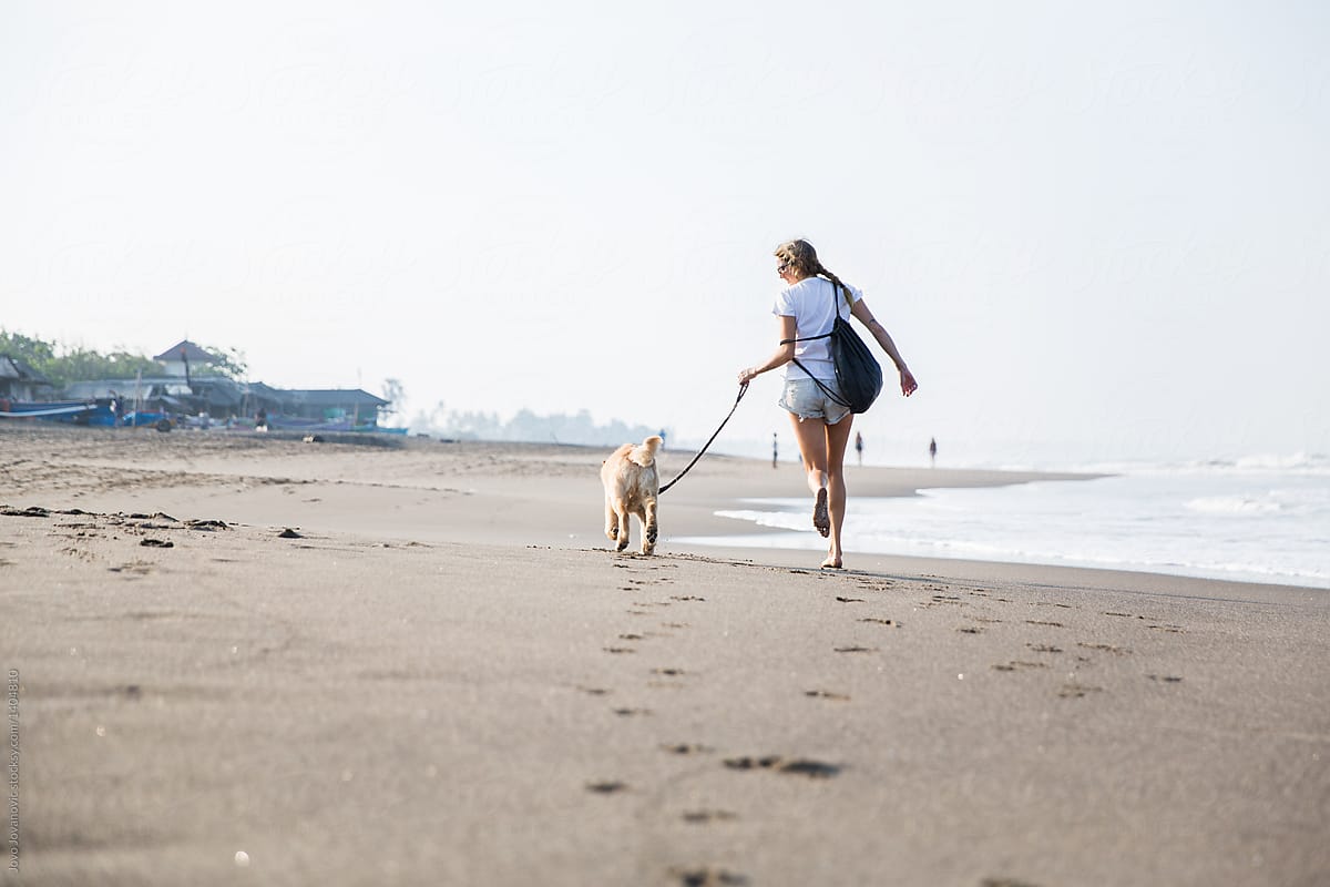 "Woman And Her Dog Running At The Beach" by Stocksy Contributor "Jovo ...
