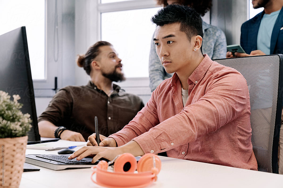 "Asian Man Working With A Graphic Tablet While Curly Hair Man And" by ...