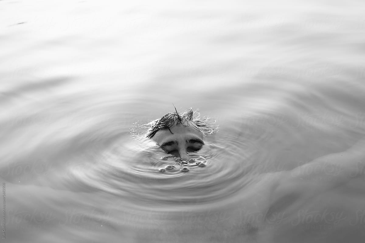 "Man Submerging In A Lake" by Stocksy Contributor "Jordi Rulló" - Stocksy
