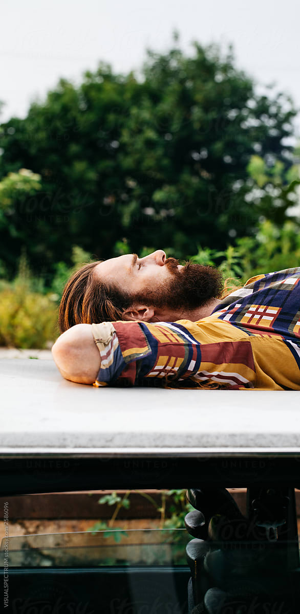 "Long-Haired Bearded Young Man Daydreaming On Car Roof" by Stocksy ...
