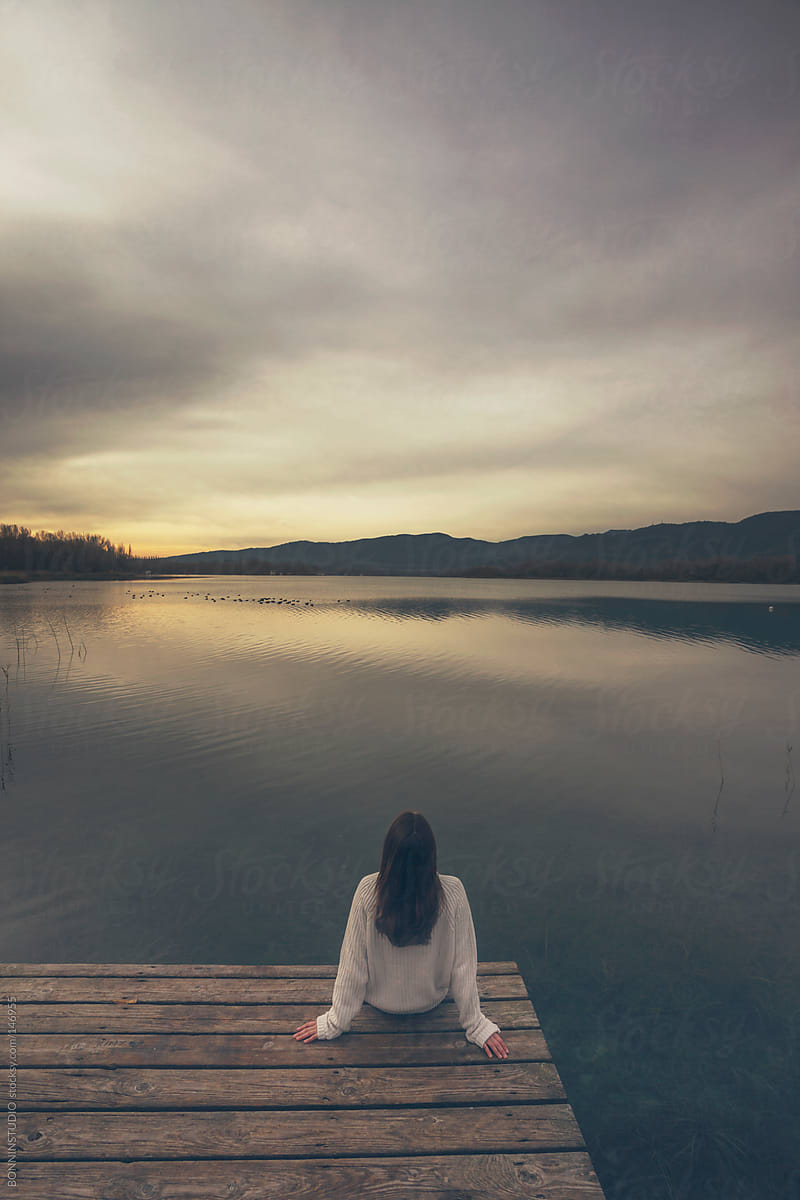 "Back View Of Woman Sitting At The Lakeshore." by Stocksy Contributor ...
