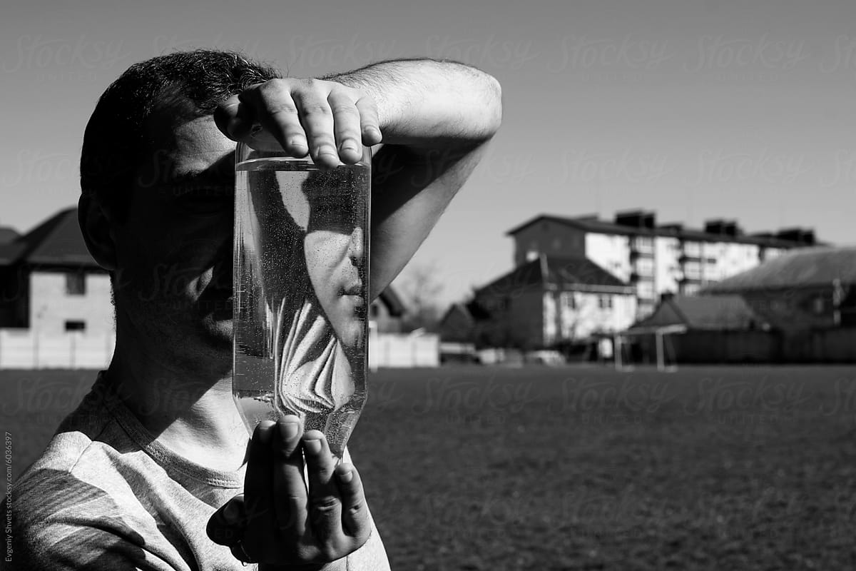 "Man Looking Through Transparent Glass Vase With Water" by Stocksy ...