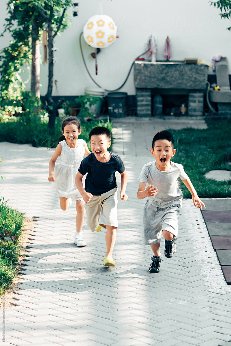 "Cute Kids Running In Yard" by Stocksy Contributor "MaaHoo" - Stocksy