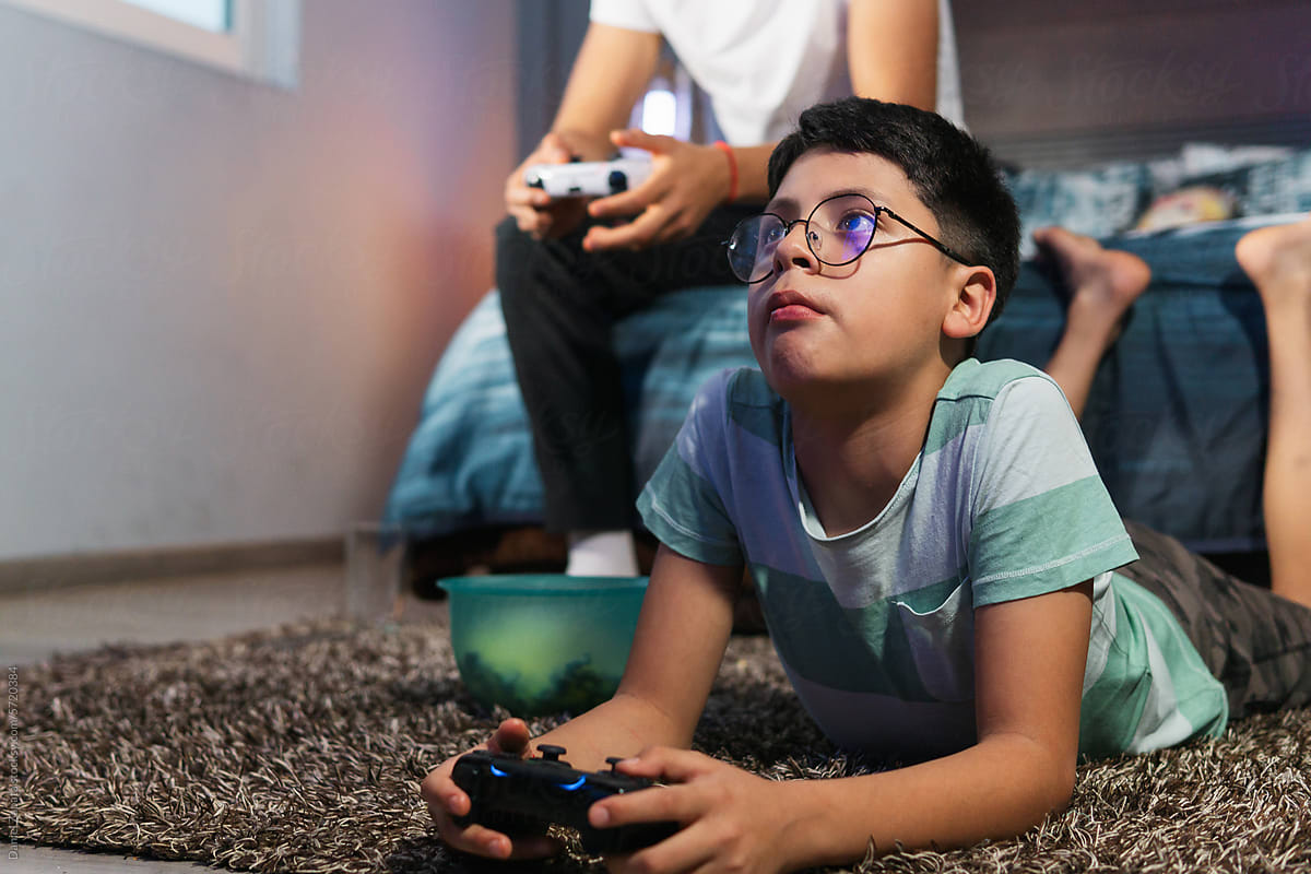 Brothers playing video games in their room. - Stock Image - Everypixel