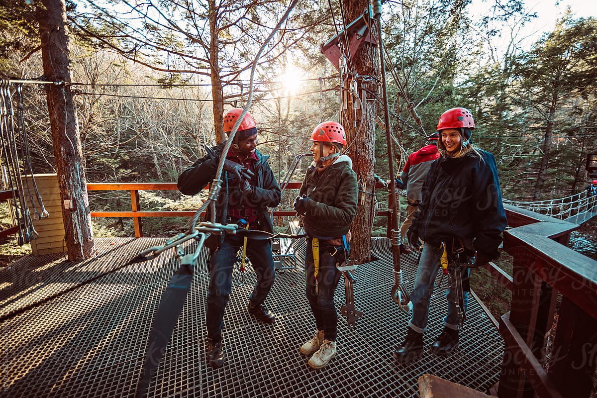 "Group Of Friends Laugh And Joke Around While On An Outdoor Zip Line ...