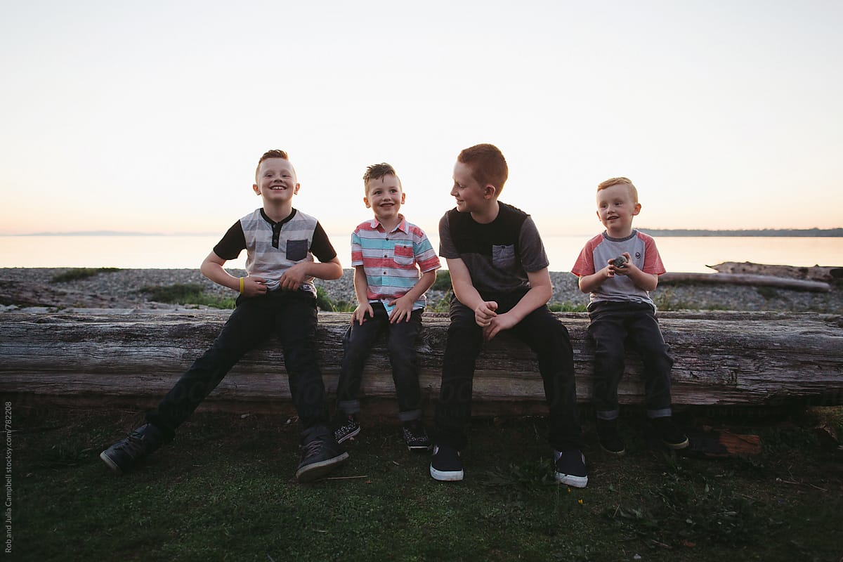 "Young Brothers Having Fun Together Outside - Sitting On A Log" by ...