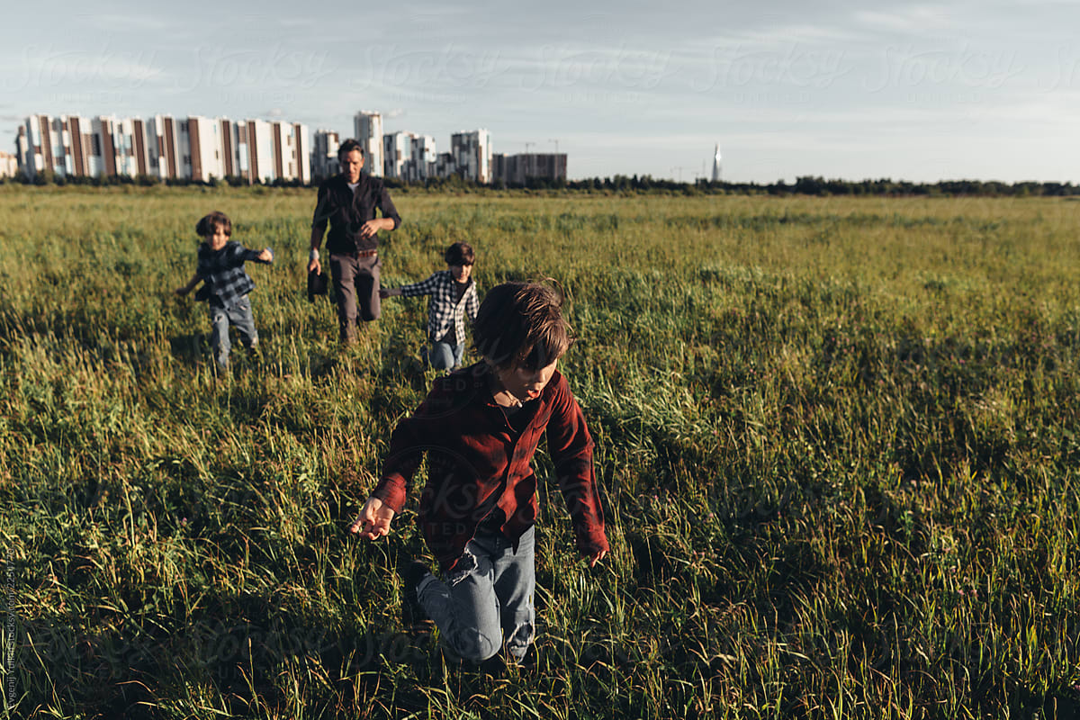 "Father And Kids In The Field" by Stocksy Contributor "Evgenij Yulkin ...