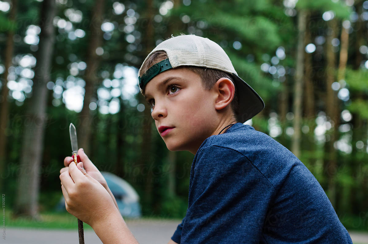 "A Boy Sharpening A Stick" by Stocksy Contributor "Ali Deck" - Stocksy