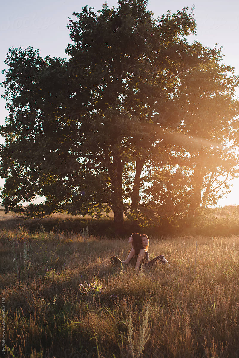 "Two Friends Sitting Under The Tree" by Stocksy Contributor "Liliya ...