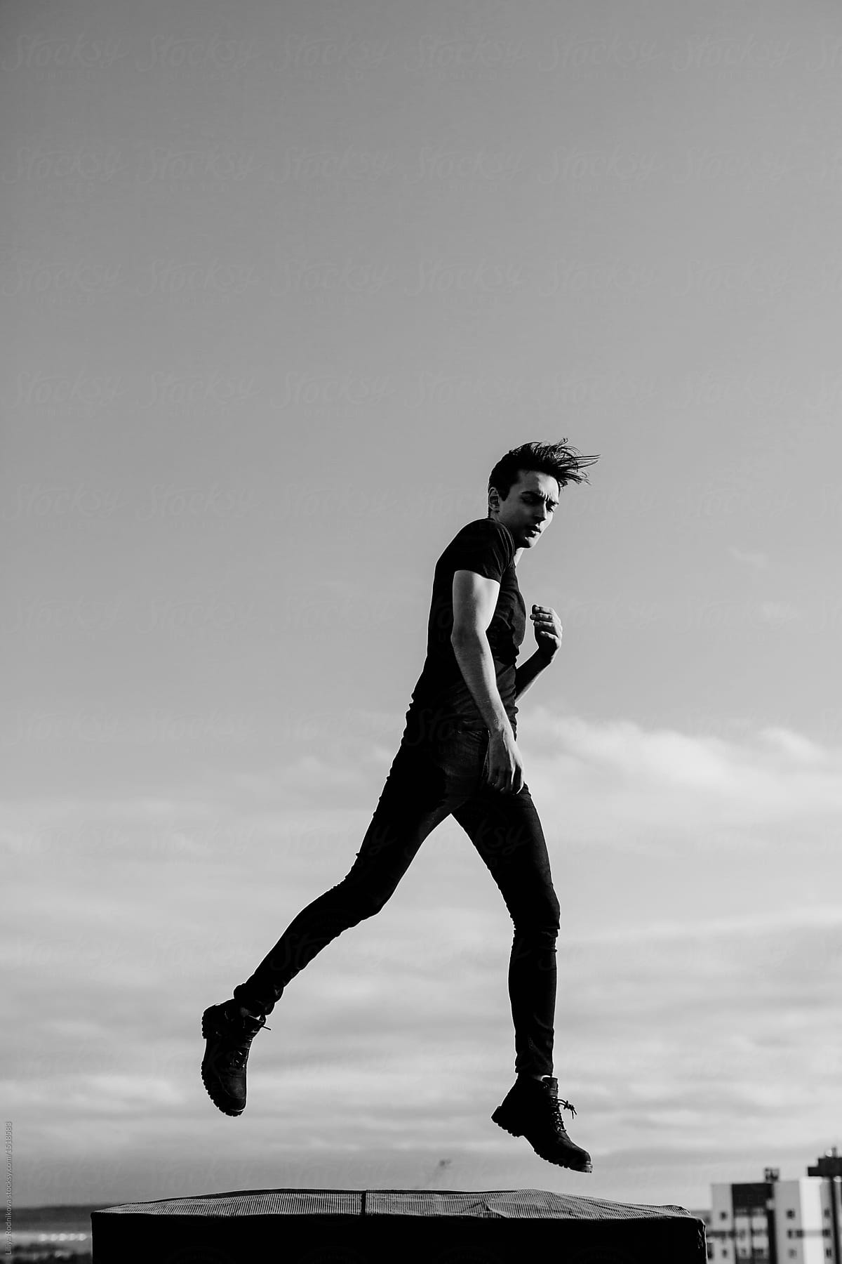 "Monochrome Portrait Of Young Man Jumping On The Roof" by Stocksy ...