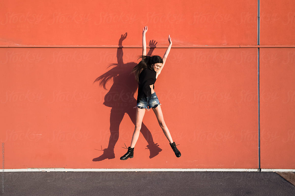 "Woman Jumping Against A Red Wall" by Stocksy Contributor "Garage ...