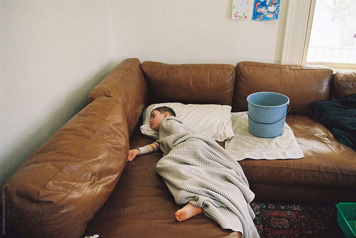"Sick Child Sleeps On Couch With Puke Bucket Nearby" by Stocksy ...