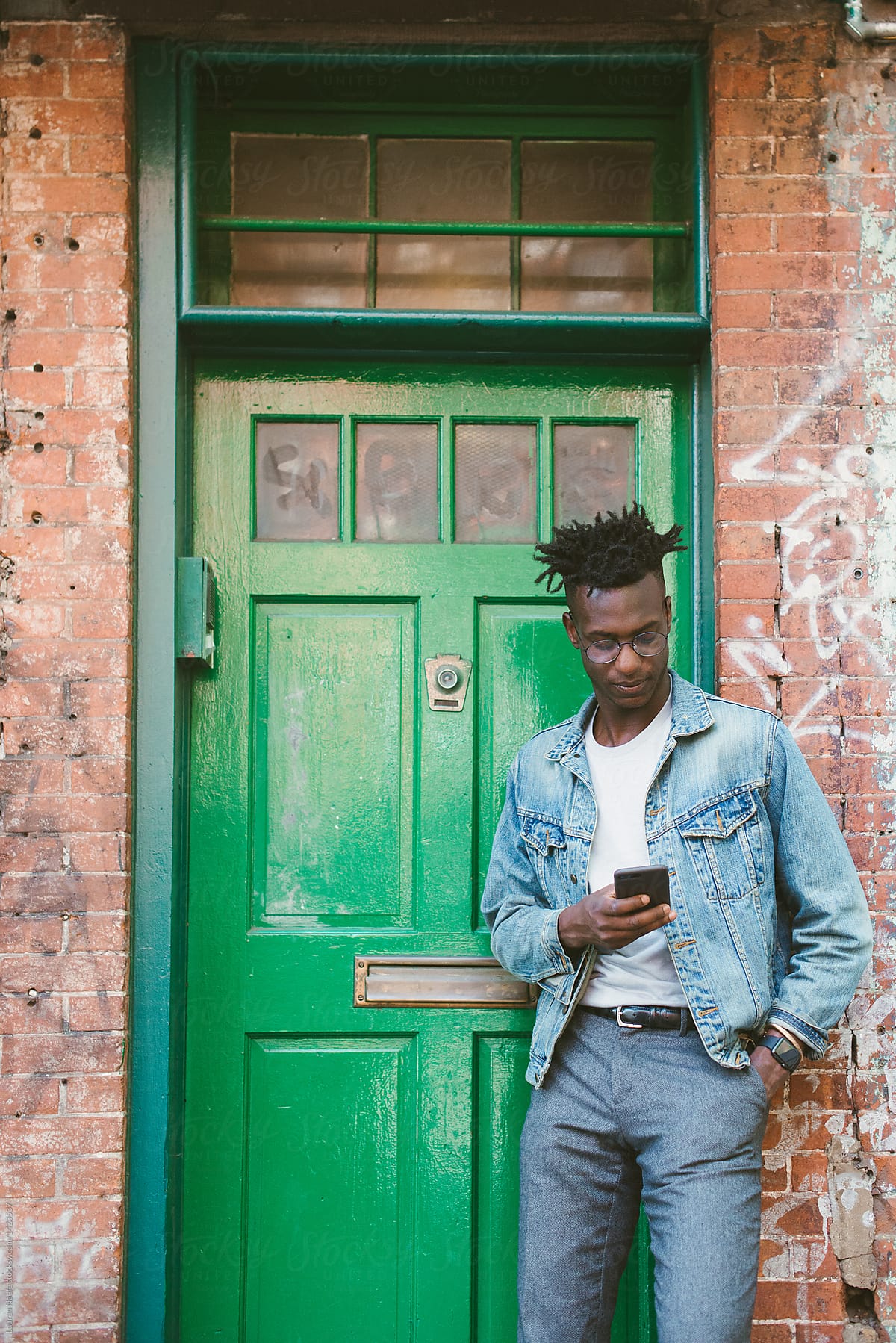 "Young Man Using Phone Outside Apartment Building" by Stocksy ...