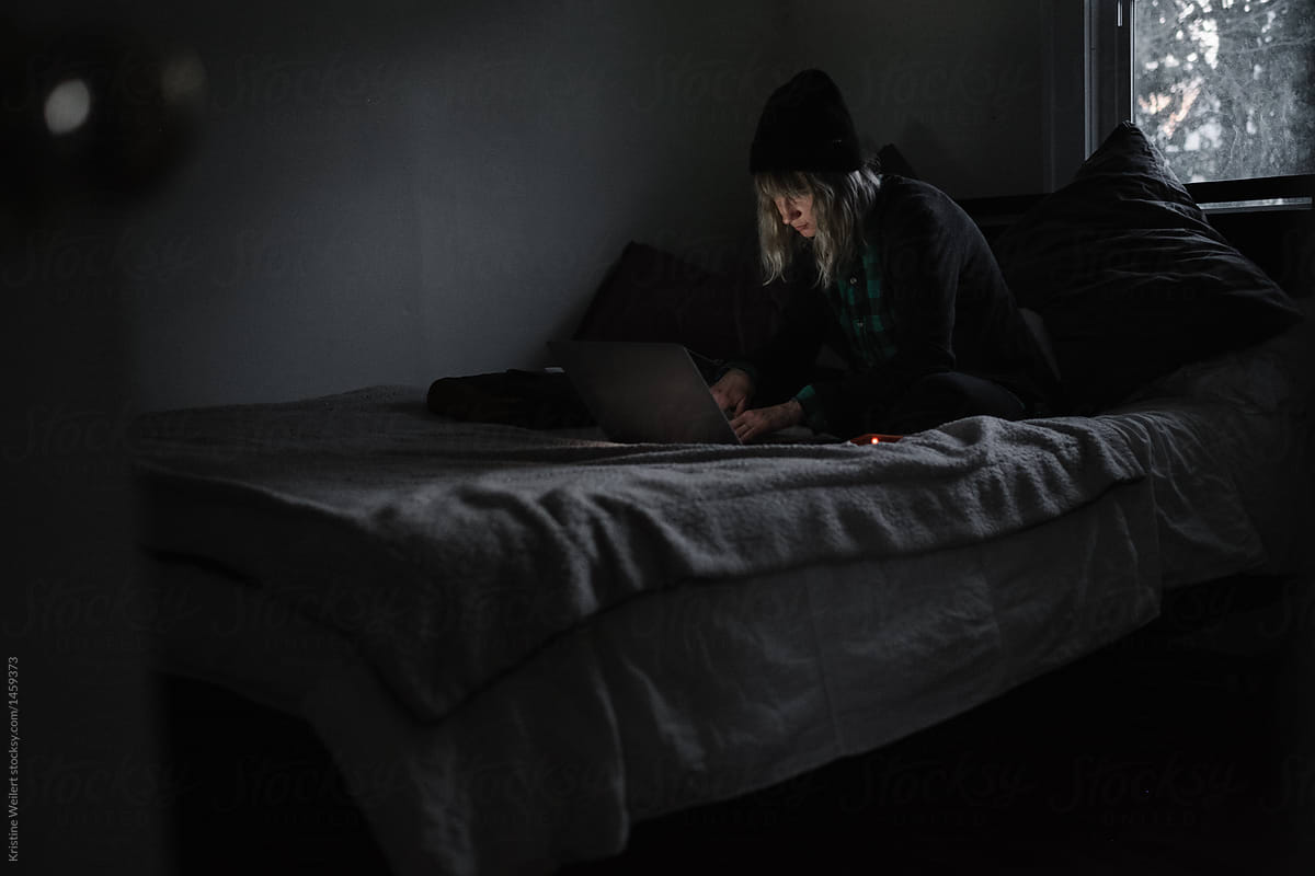 "Woman Working On Laptop In Dark Room" by Stocksy Contributor "Kristine ...