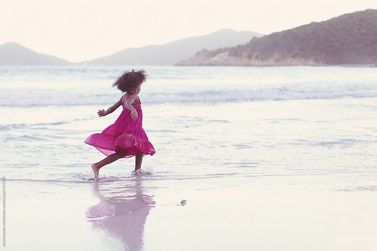 "A Child Running In The Waves While On The Beach" by Stocksy ...