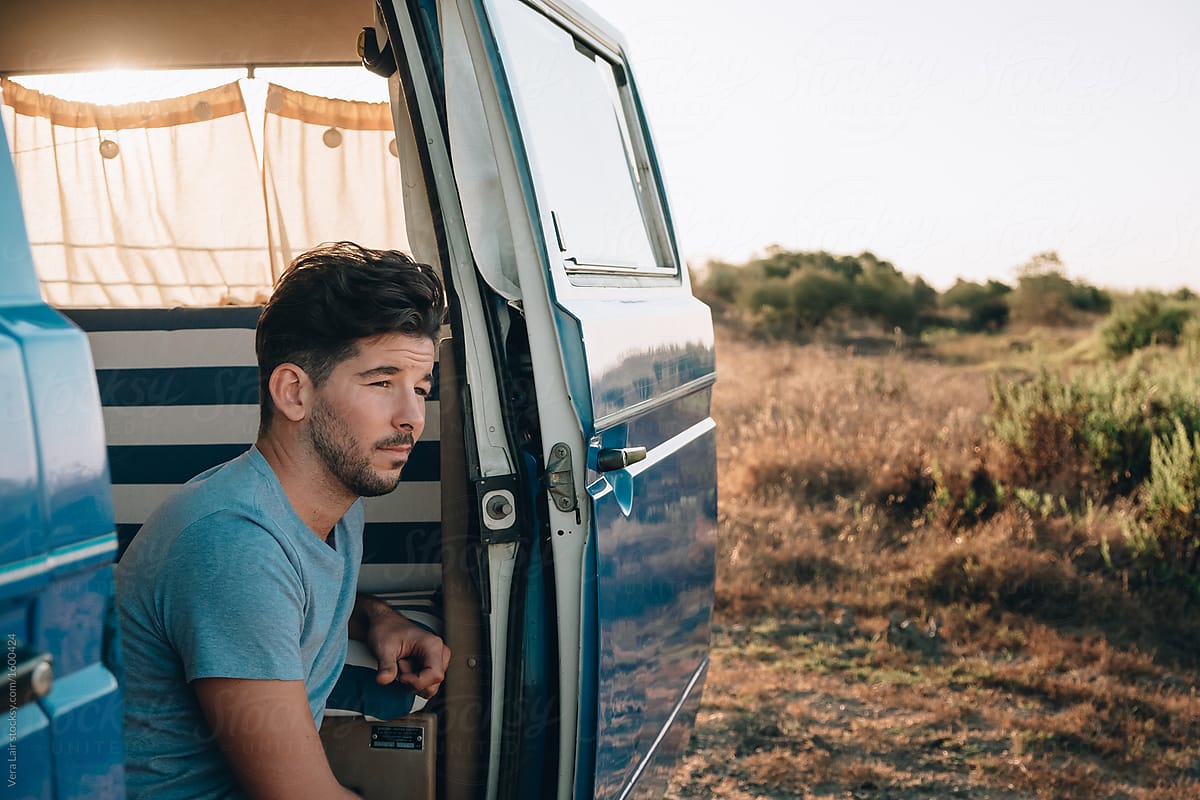 Portrait of a man sitting in a blue van - Stock Image - Everypixel
