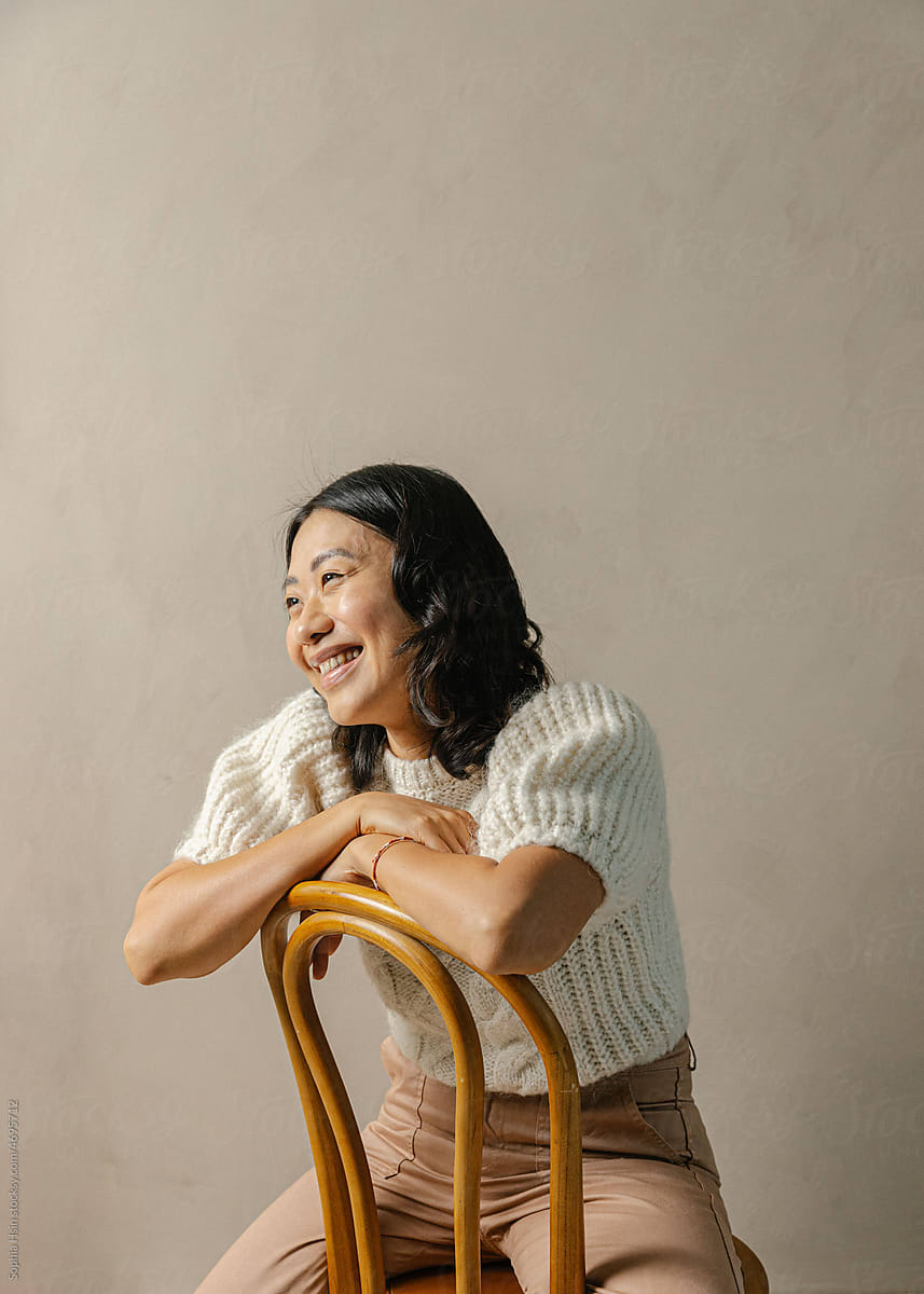 Self-portrait of seated smiling young woman - Stock Image - Everypixel