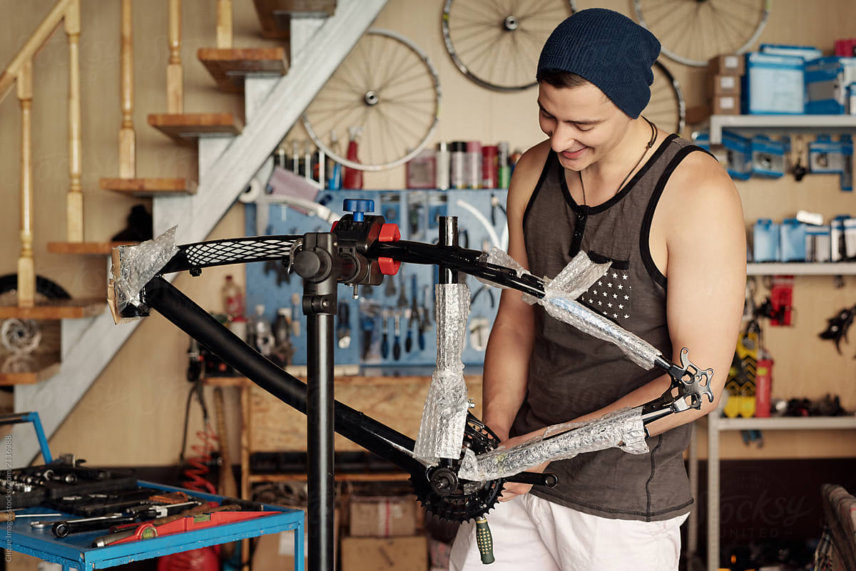 "Happy Serviceman Repairing Bicycle" by Stocksy Contributor "Clique ...
