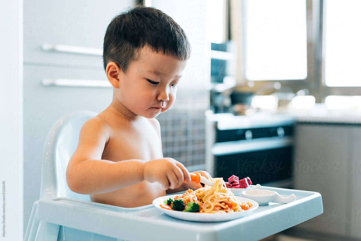 "Adorable Boy Eating At Home" by Stocksy Contributor "MaaHoo" - Stocksy