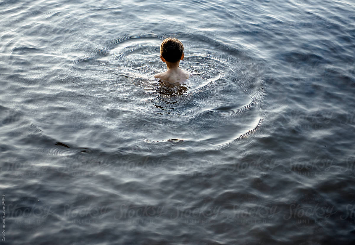 "Boy Wades In Shallow Lake Water At Sunset" by Stocksy Contributor ...