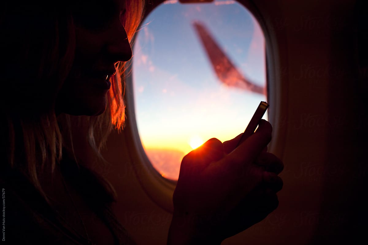 "Young Woman Sitting In An Airplane Using Her Phone" by Stocksy ...