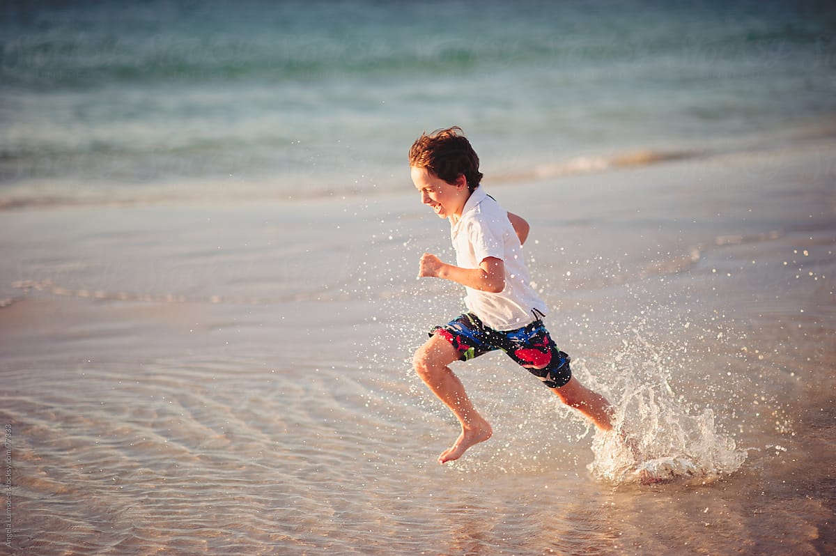 "Boy Running Through Water At The Beach" by Stocksy Contributor "Angela ...